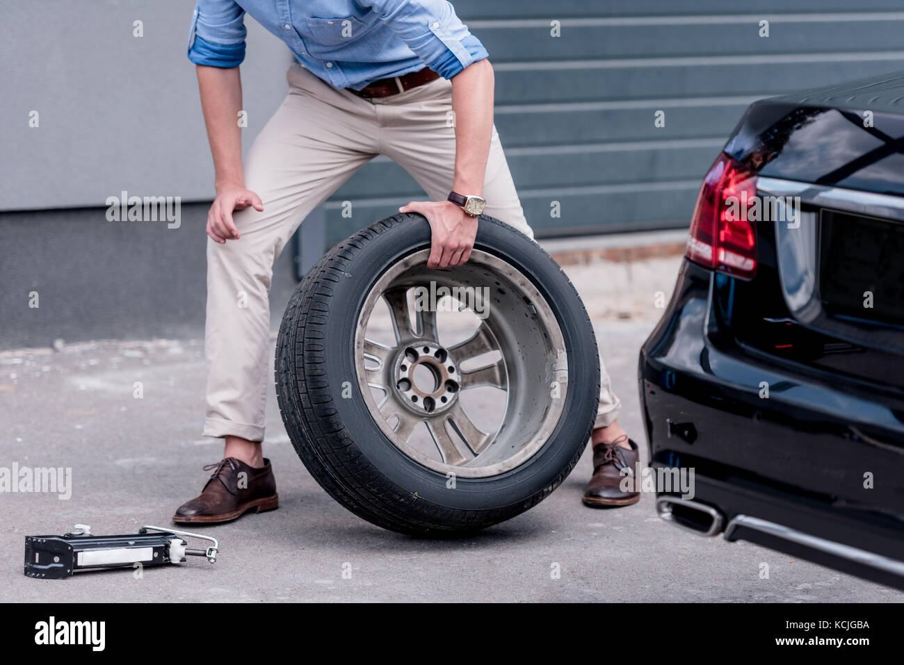 man changing car tire Stock Photo - Alamy