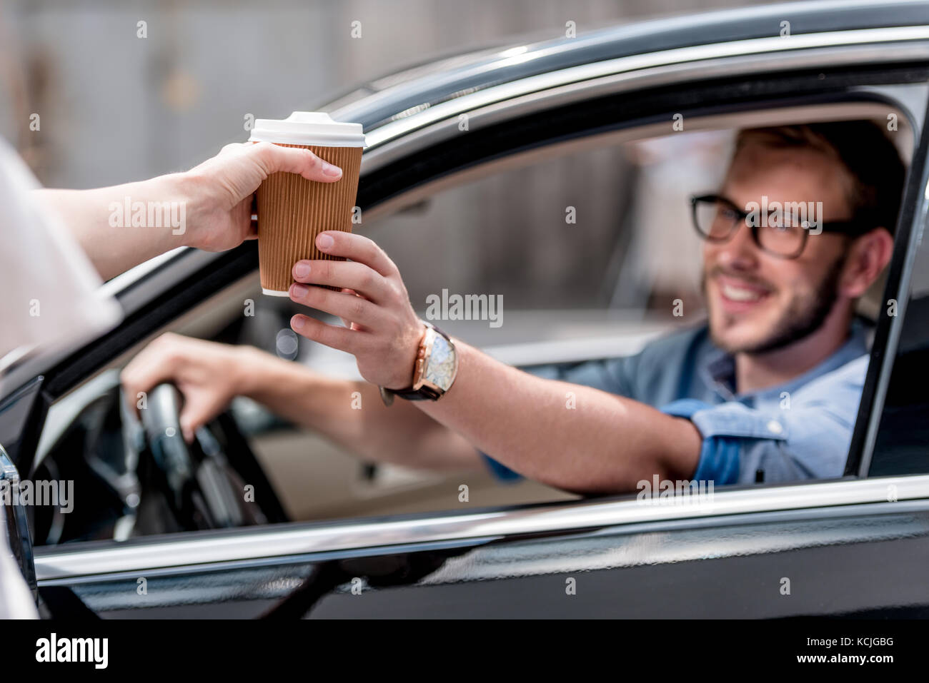 man with coffee in car Stock Photo - Alamy