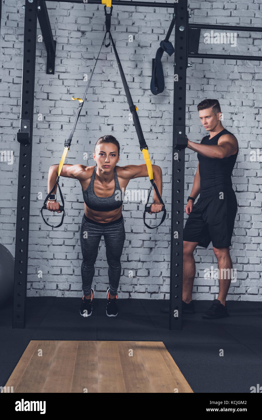 woman exercising with trx gym equipment Stock Photo - Alamy