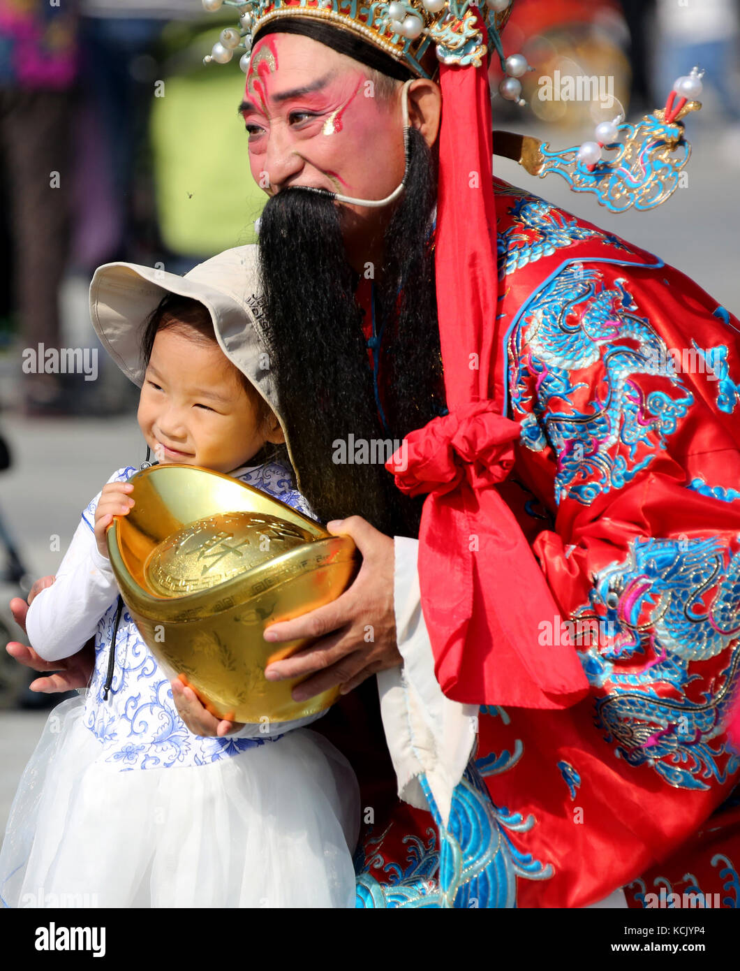 Beijing, China. 5th Oct, 2017. A child poses for photo with "the god ...