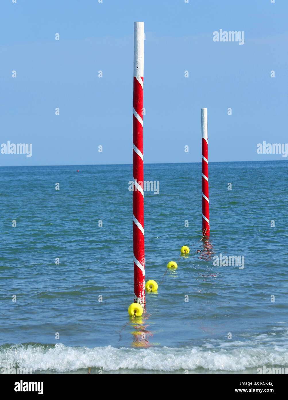 white and red colored poles on the sea to moor the boats Stock Photo ...