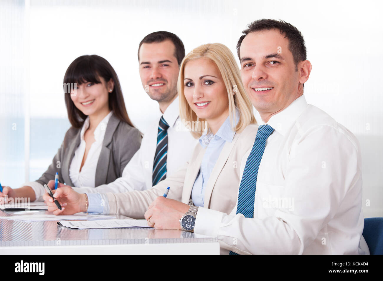 Business People Writing Meeting Notes In Office Stock Photo - Alamy