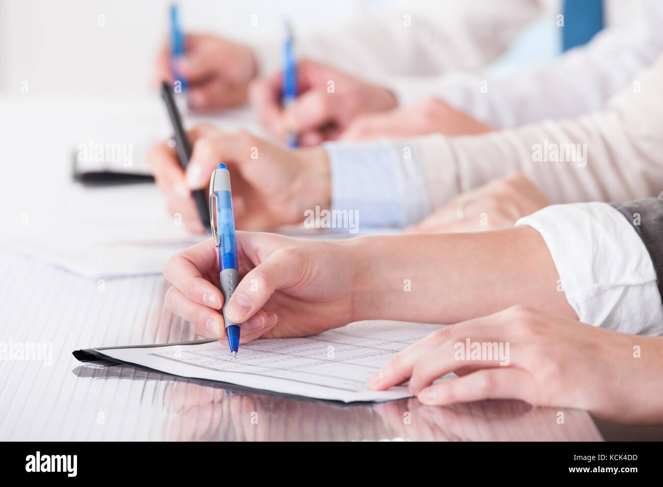 Business People Sitting In A Row And Writing Notes In Office Stock ...