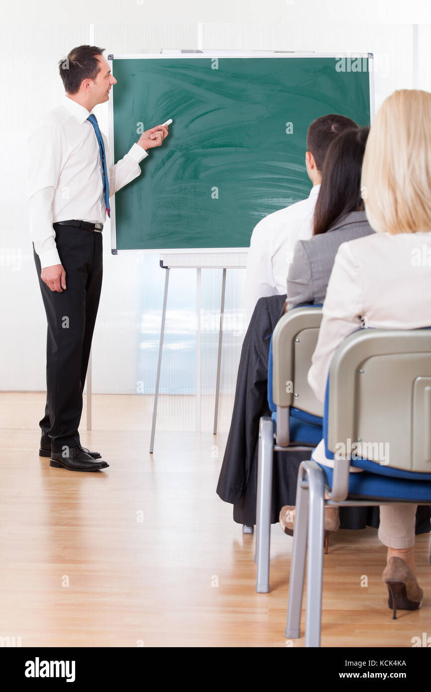 Business Man Writing On Board In Office Stock Photo - Alamy