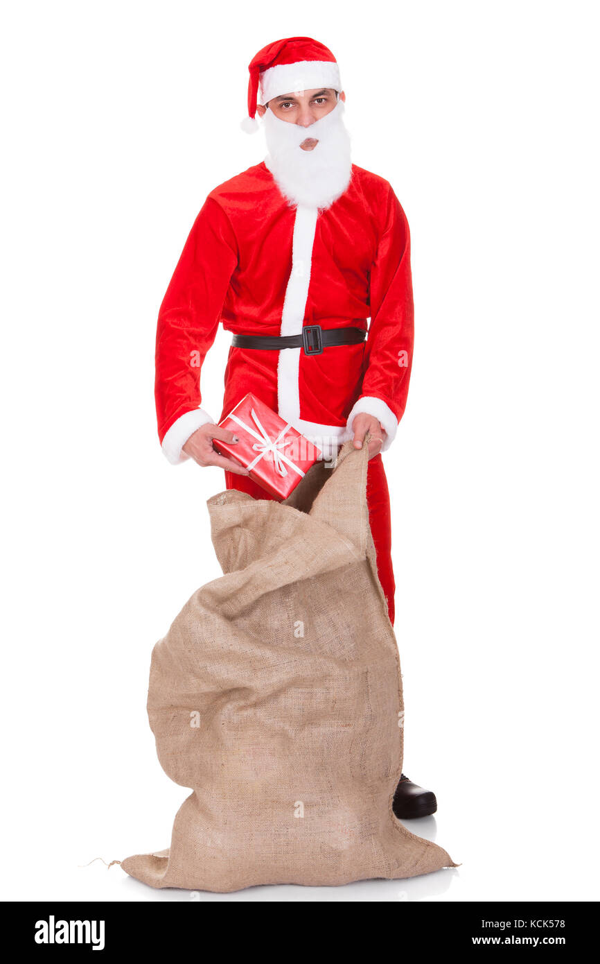 Santa Filling Bag With Gifts On White Background Stock Photo - Alamy