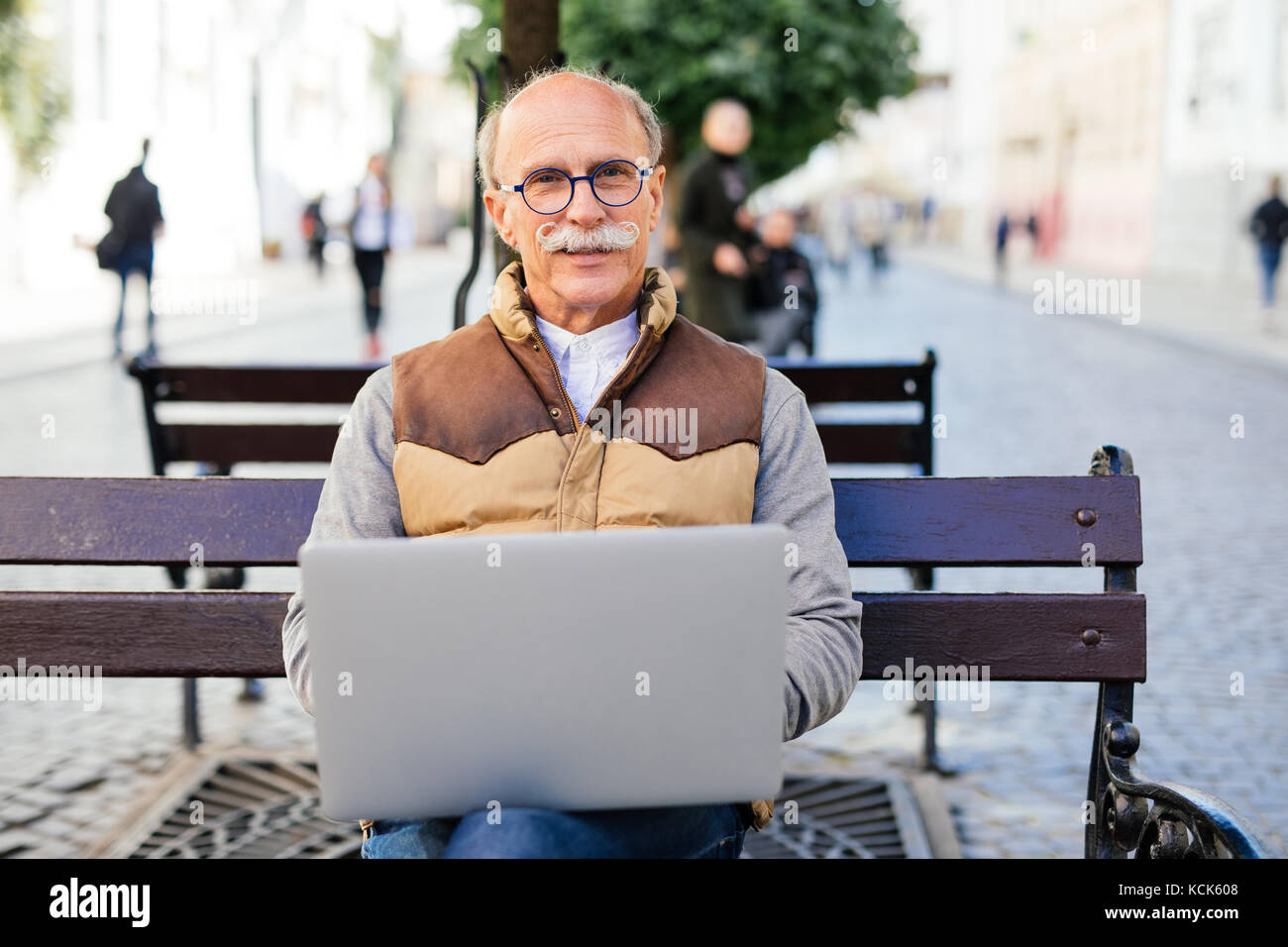 Senior man working on his laptop city street Stock Photo - Alamy