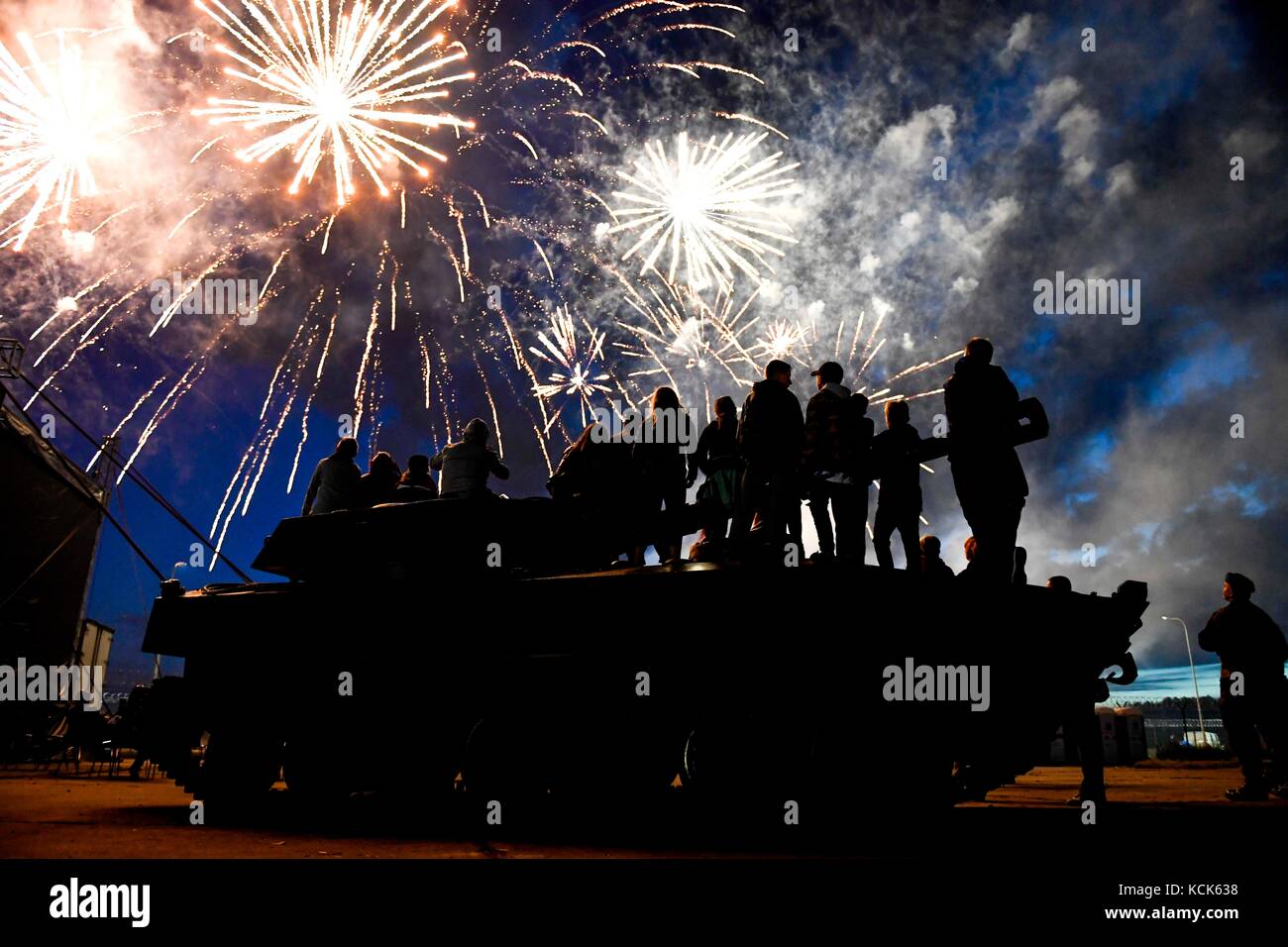 U.S. and Polish soldiers watch fireworks from atop a battle tank during ...