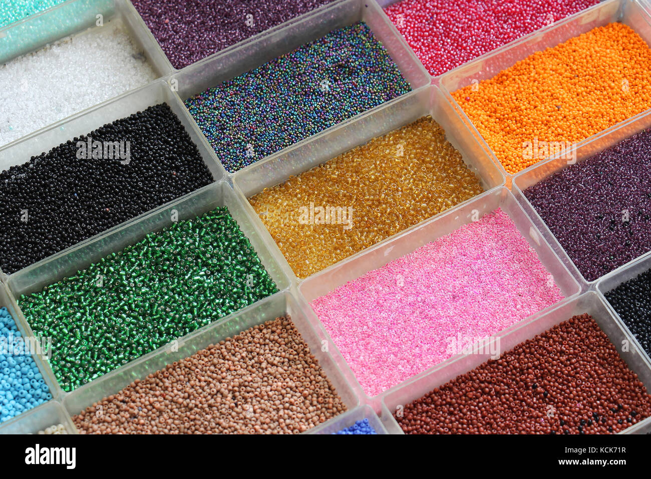 Small decorative colorful beads in plastic containers Stock Photo - Alamy