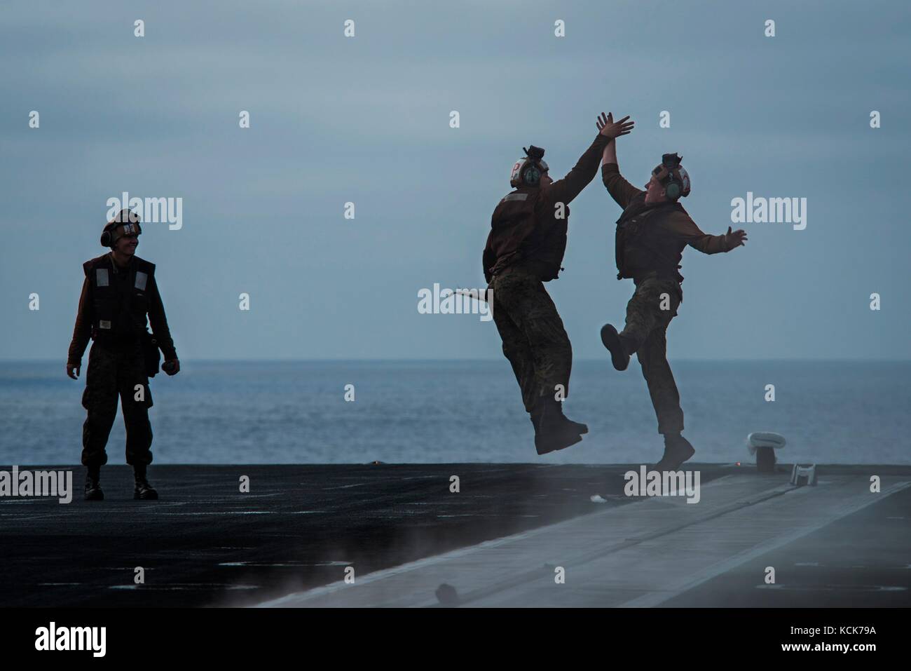 U.S. soldiers high-five each other on the flight deck of the U.S. Navy ...