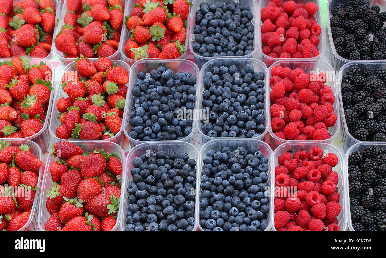 Organic fresh berries in plastic containers on market stall Stock Photo ...