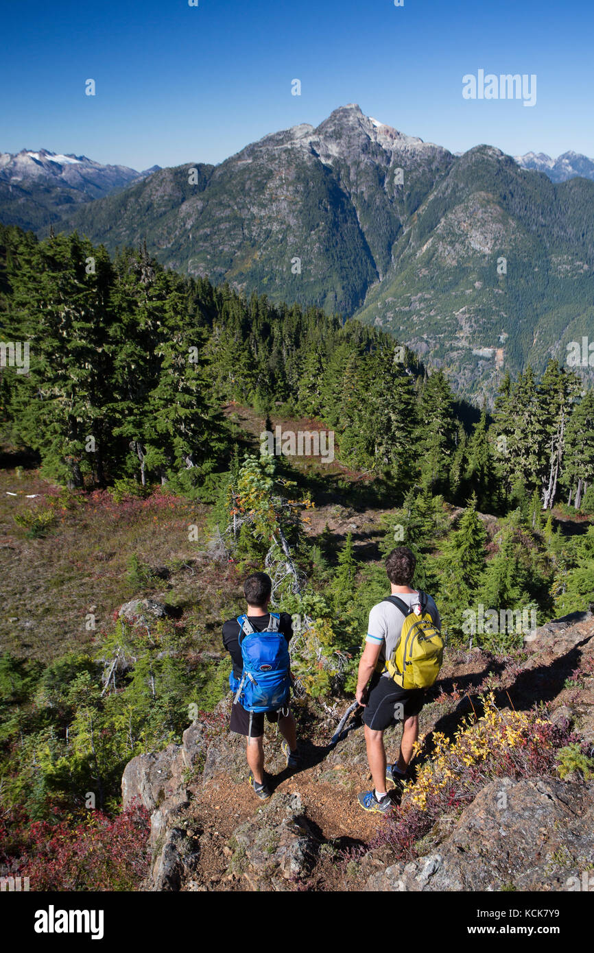 Two male hikers stop and take in the view looking back towards ...
