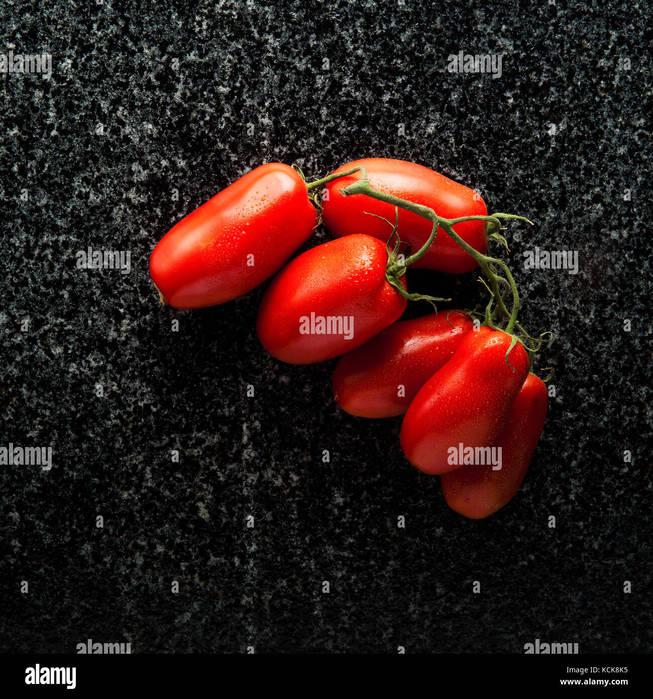 ripe tomatoes on black marble Stock Photo - Alamy
