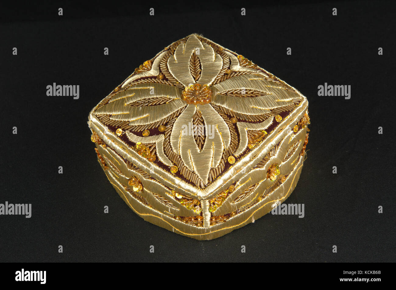 gold colored traditional asian skullcap cap on a dark background Stock ...