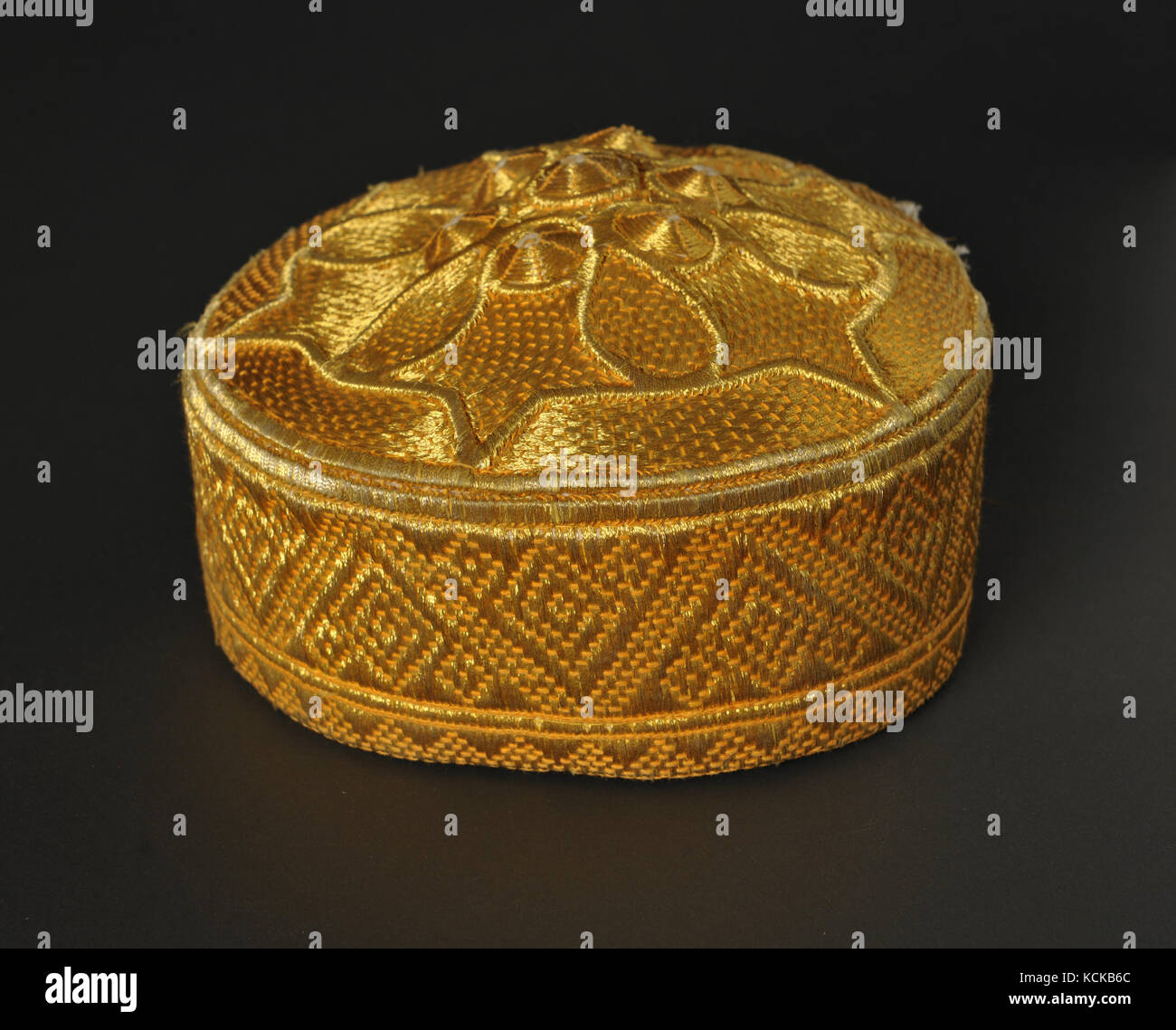 gold colored traditional asian skullcap cap on a dark background Stock ...