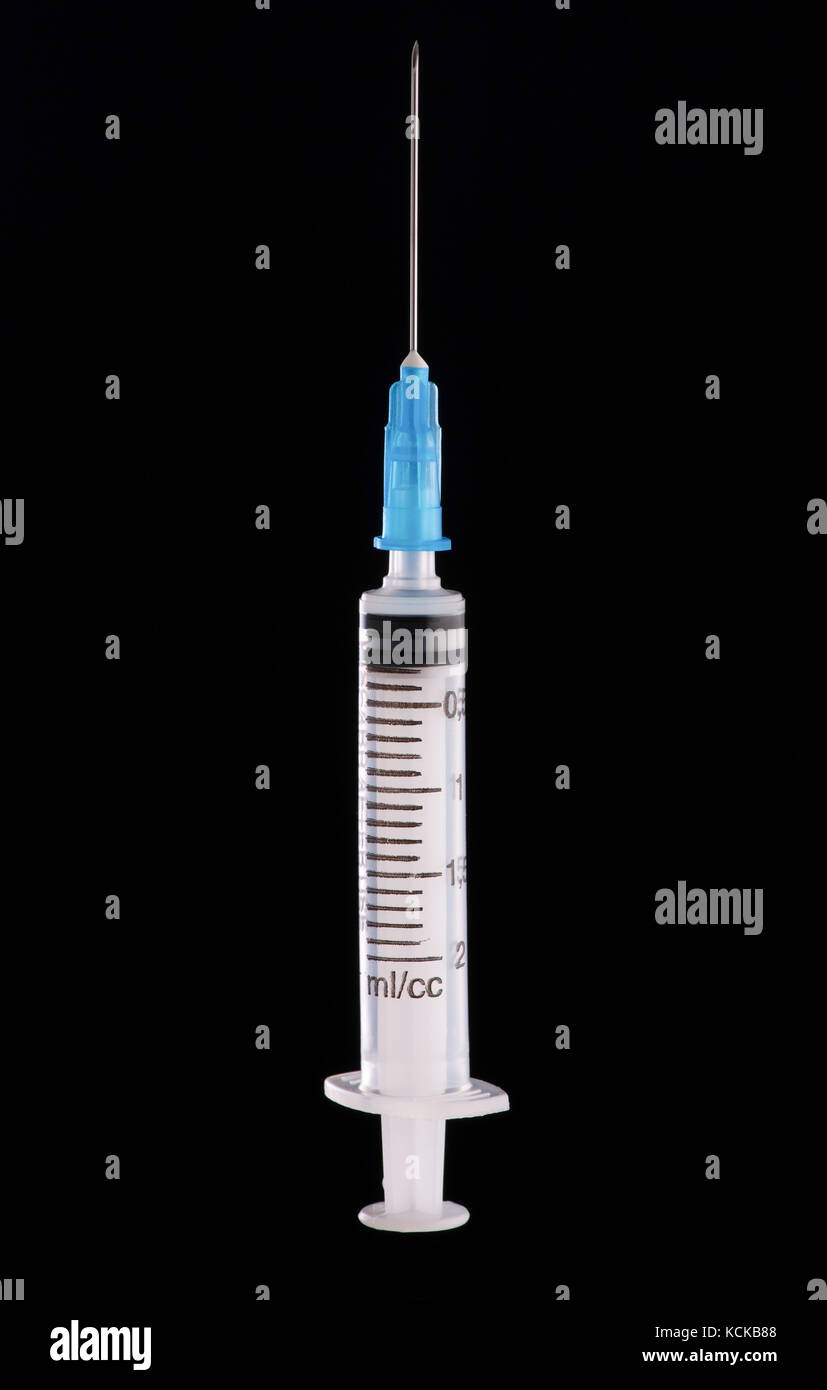 one medical syringe in an upright position on a dark blue background ...