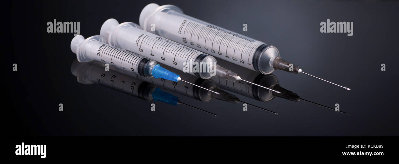 medical syringes on a dark gray background with reflection Stock Photo ...
