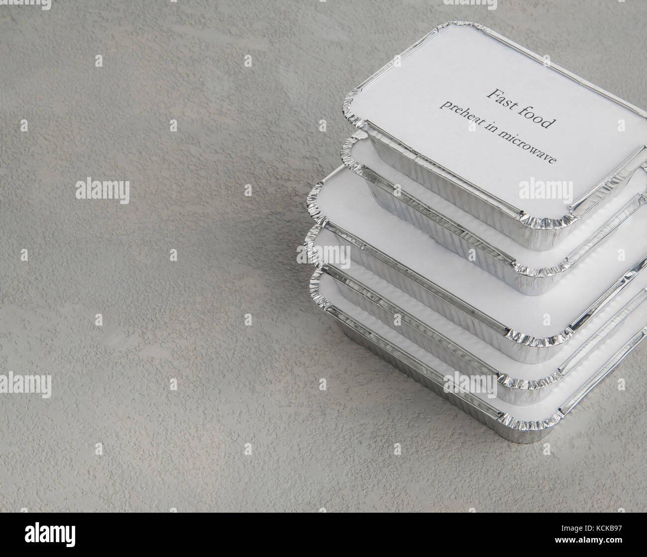 set of fast food in a box of foil on a gray rough background. food for ...