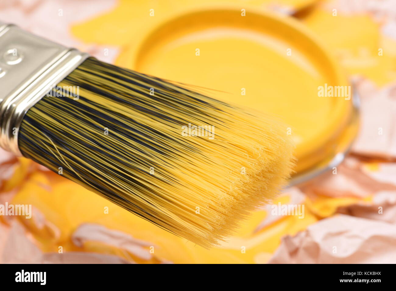 Paintbrush and can lid with yellow paint, closeup Stock Photo - Alamy