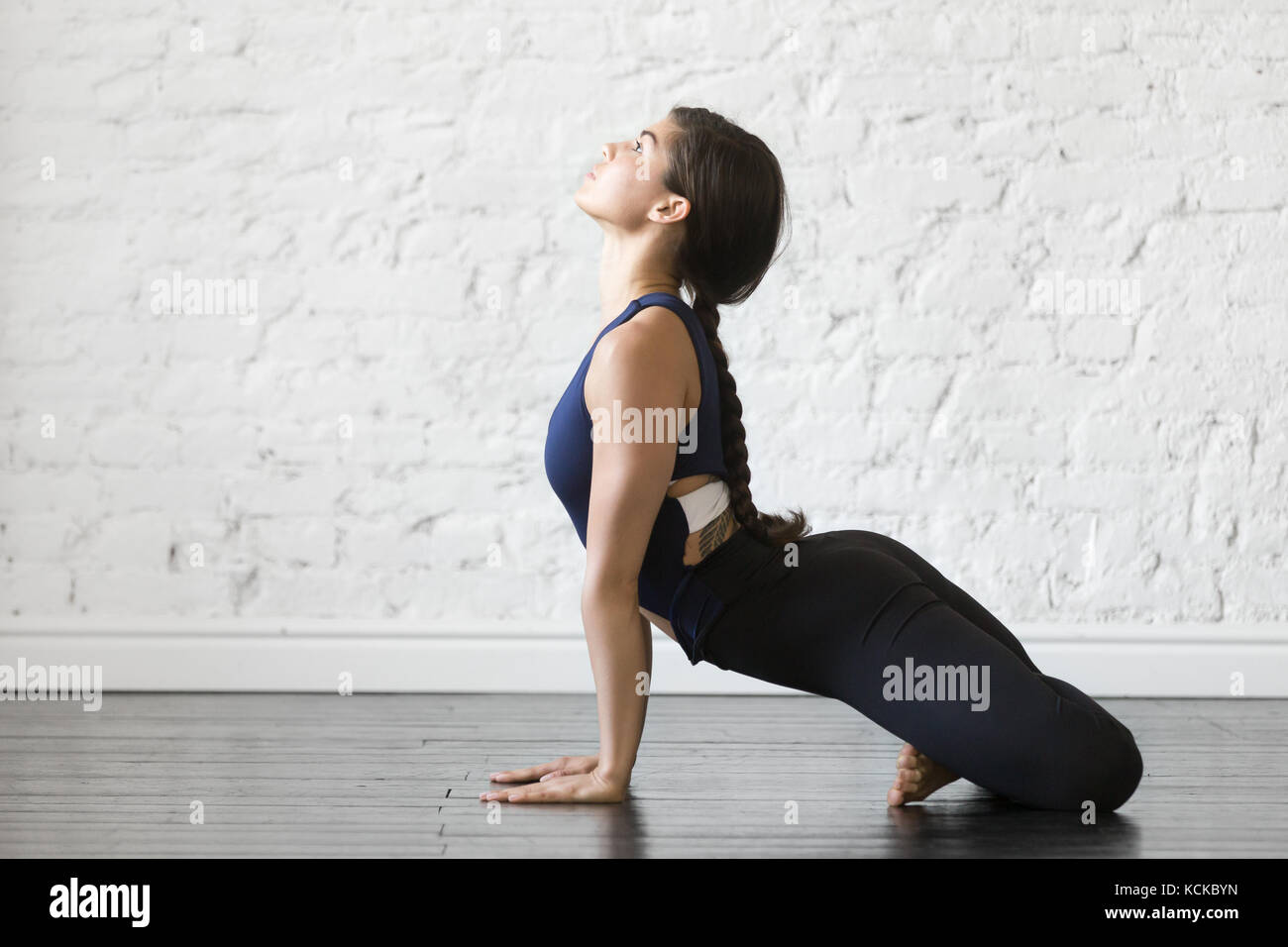 Young Woman Practicing Yoga Stretching In Upward Facing Dog With