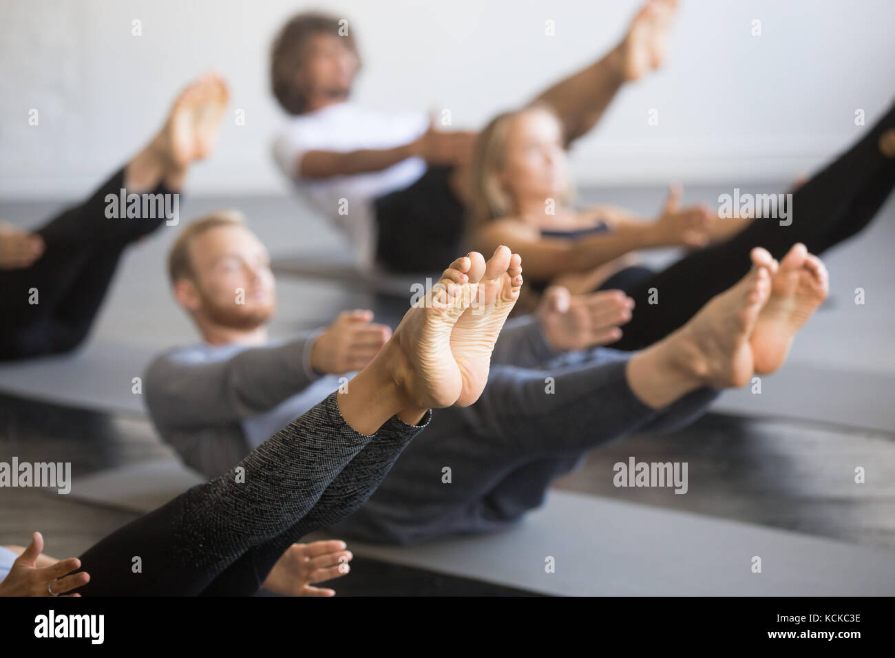 Group of young sporty people practicing yoga lesson with instructor ...