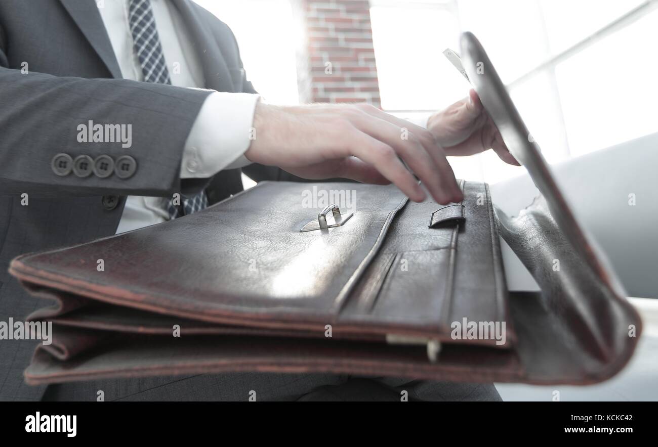 businessman's hand with suitecase in a modern office Stock Photo - Alamy