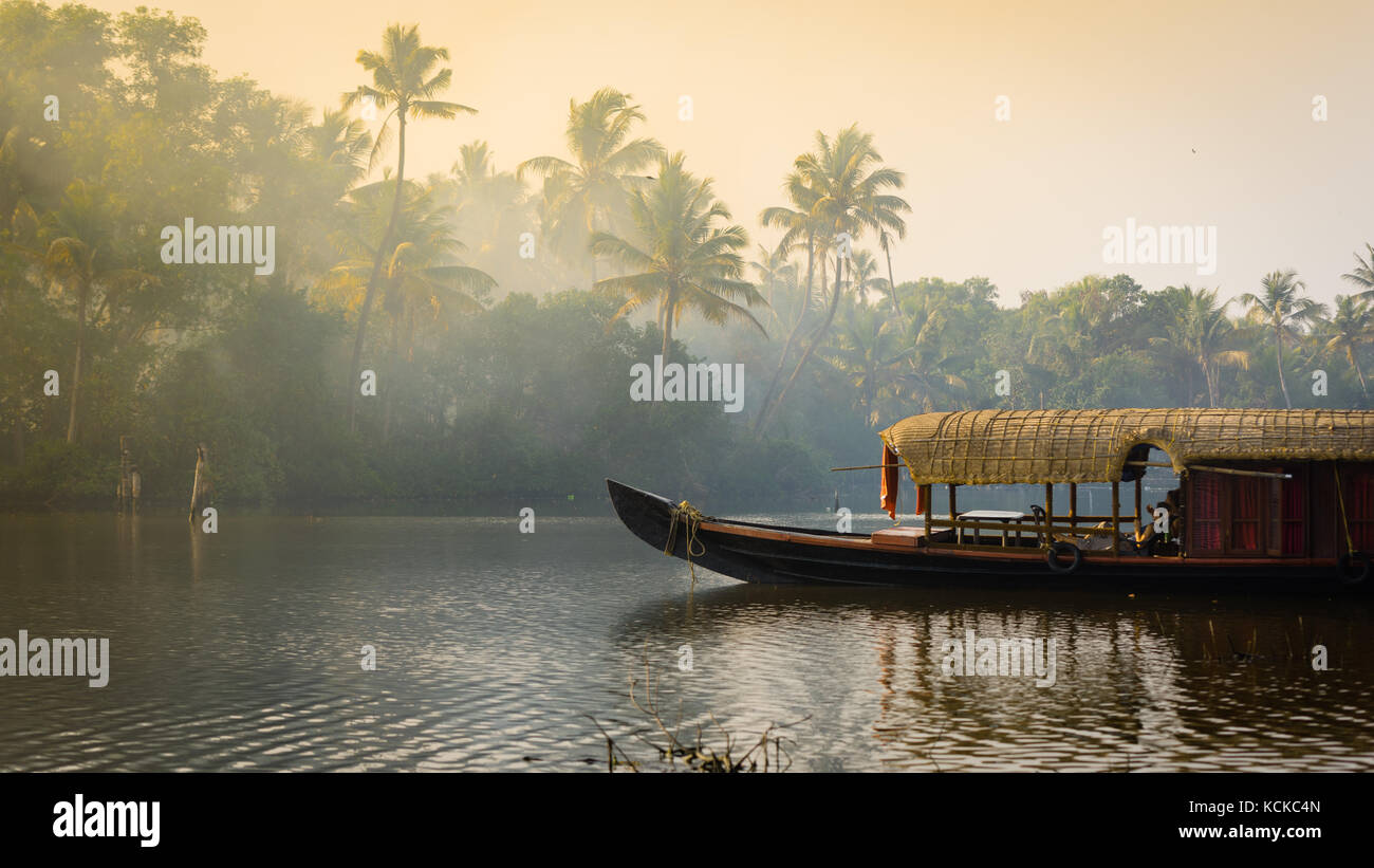 A traditional house boat is anchored on the shores of a fishing lake in ...