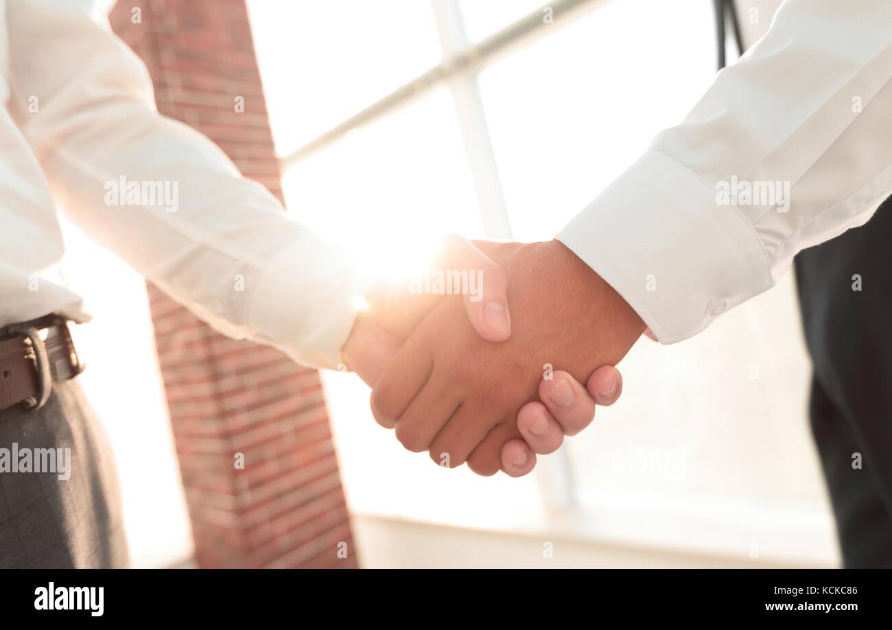 Closeup of a business handshake, on bright background Stock Photo - Alamy