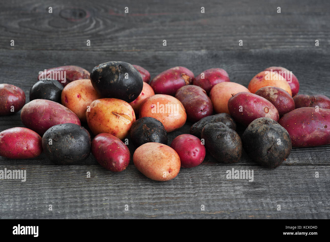 Fresh colorful potatoes on the wooden brown table Stock Photo - Alamy