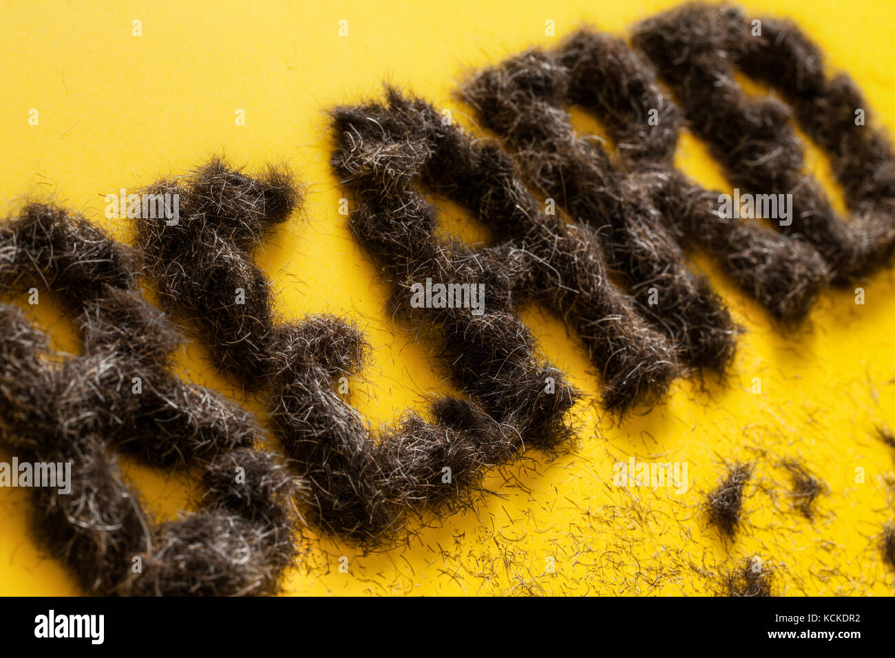 Beard sign made in beard trimming angled on a bright yellow background ...