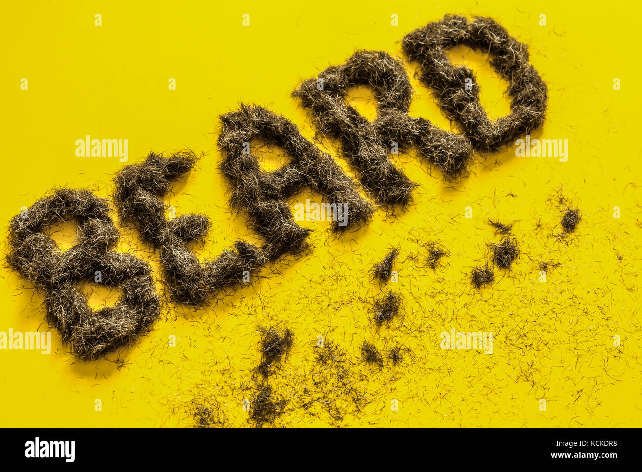 Beard sign made in beard trimming angled on a bright yellow background ...