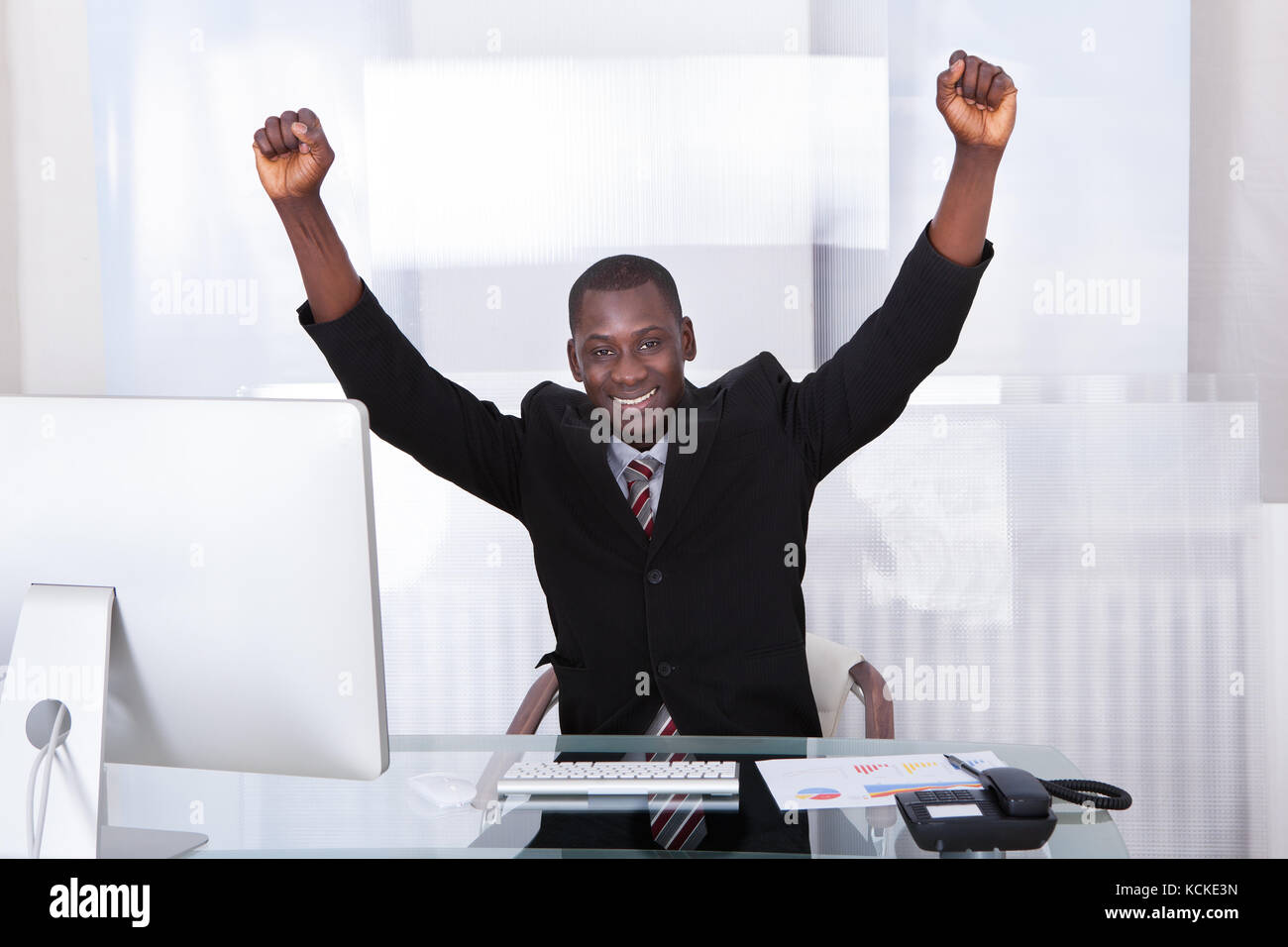 Excited Young Businessman Raising His Hands In Joy Stock Photo - Alamy