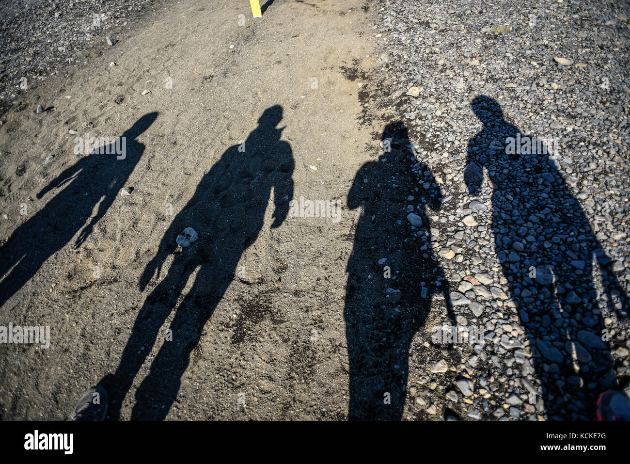 Shadow of people walking the road during sunset Stock Photo - Alamy