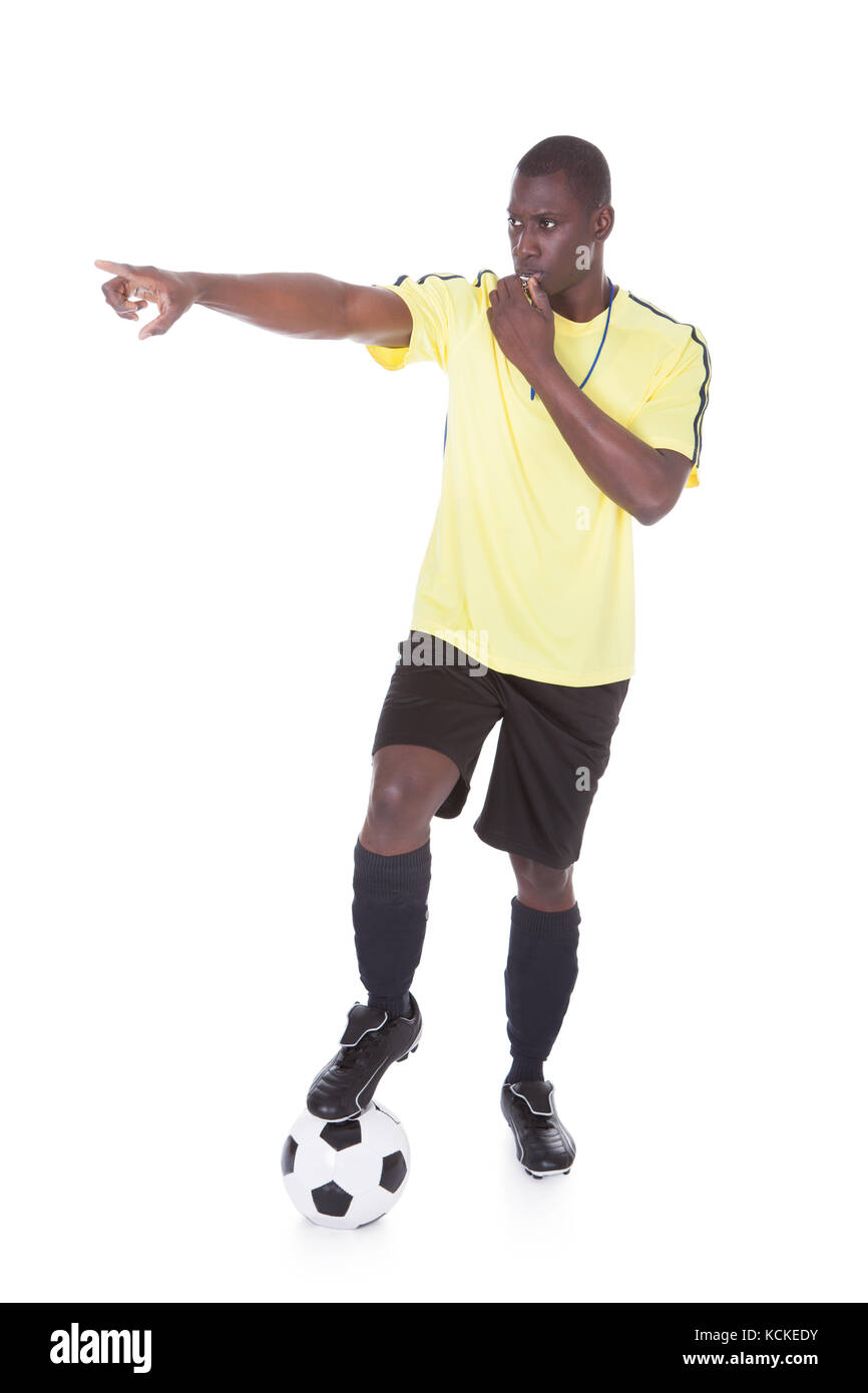 Soccer Referee Blowing Whistle With Leg On Ball Over White Background ...