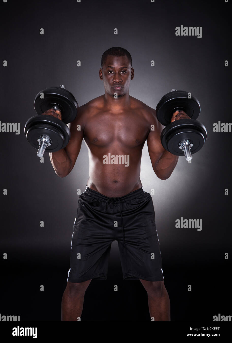 Portrait Of Young African Man Working Out With Dumbbells On Black ...