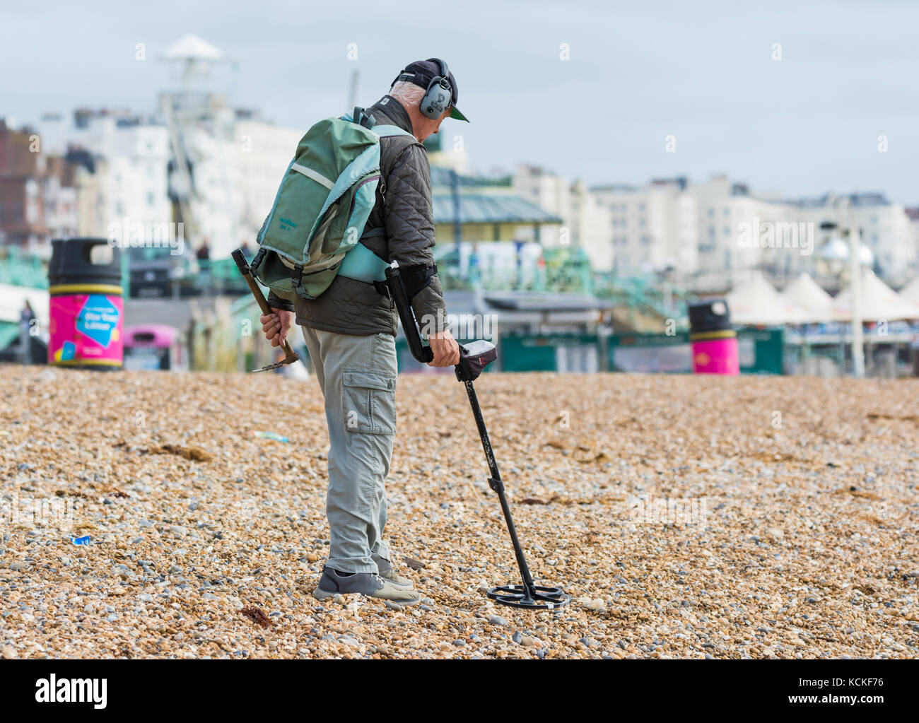 Metal detectorist searching for hidden treasure on a shingle beach in ...