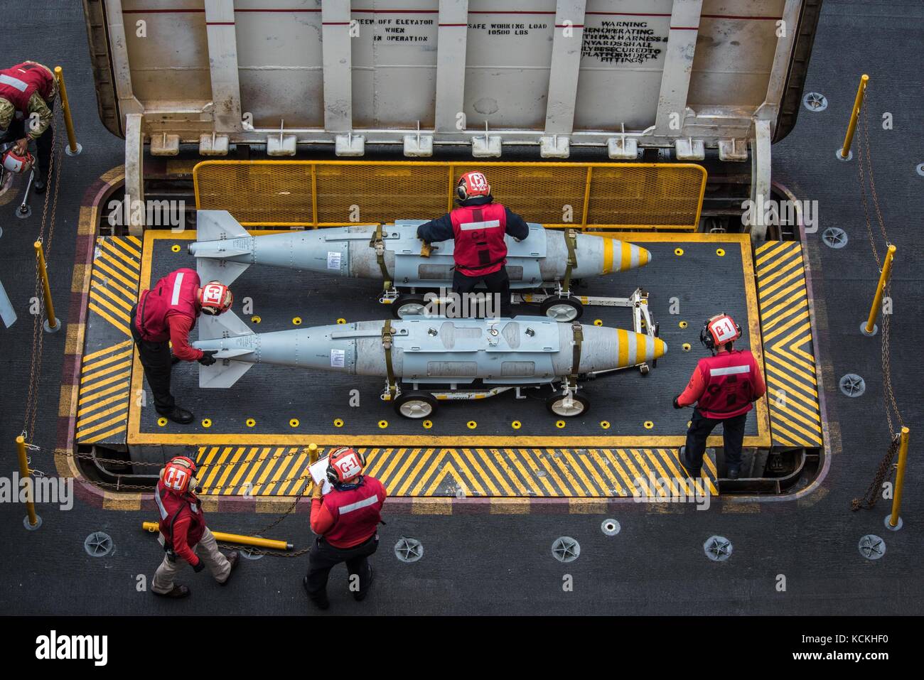 U.S. sailors handle ordnance on the flight deck aboard the U.S. Navy ...