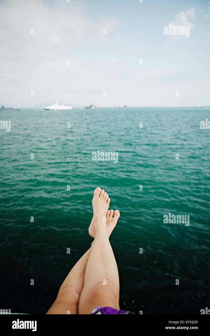 Crop female feet above sea water Stock Photo - Alamy
