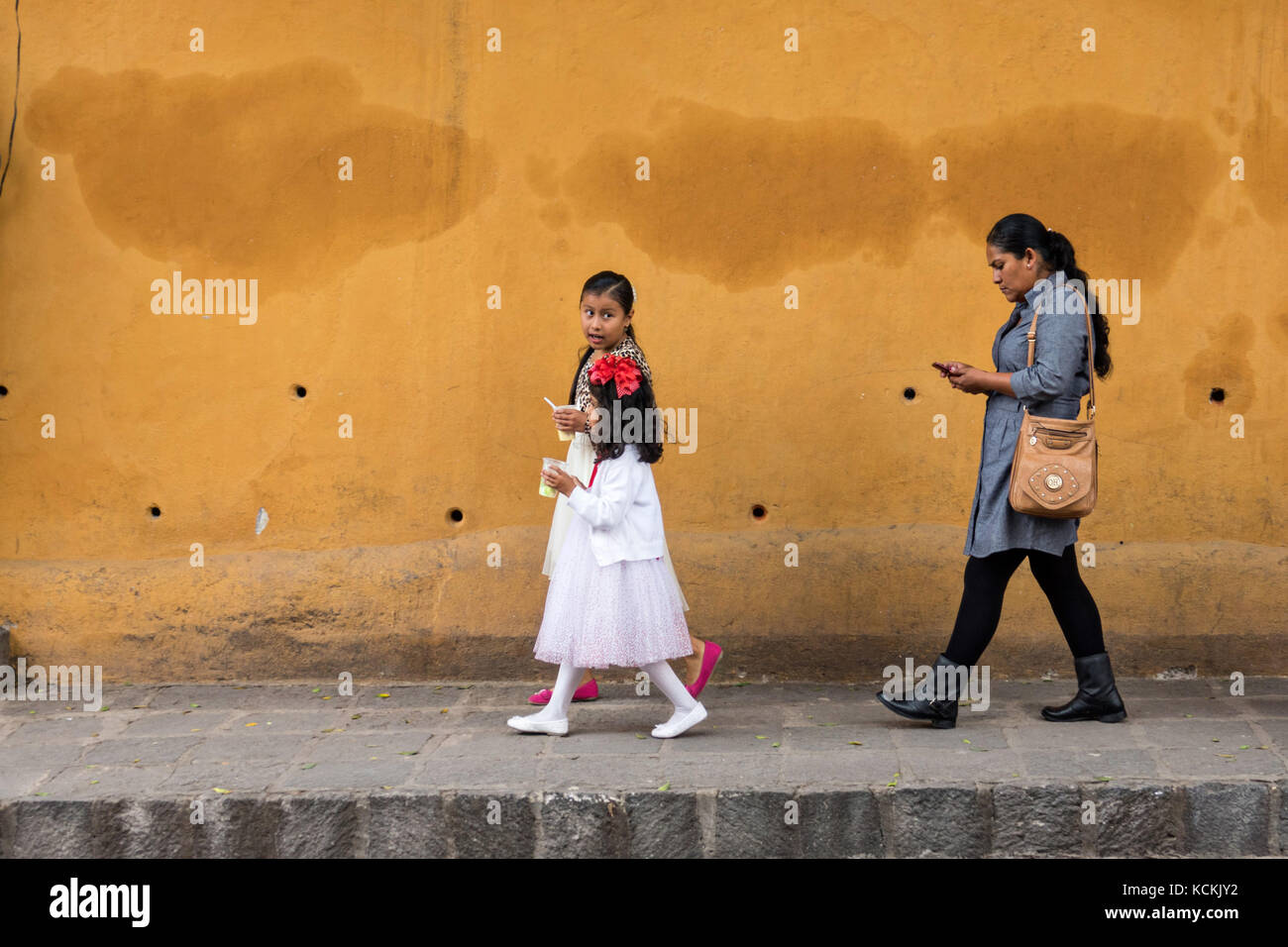 Young Mexican girls walk ahead of their mother after attending ...