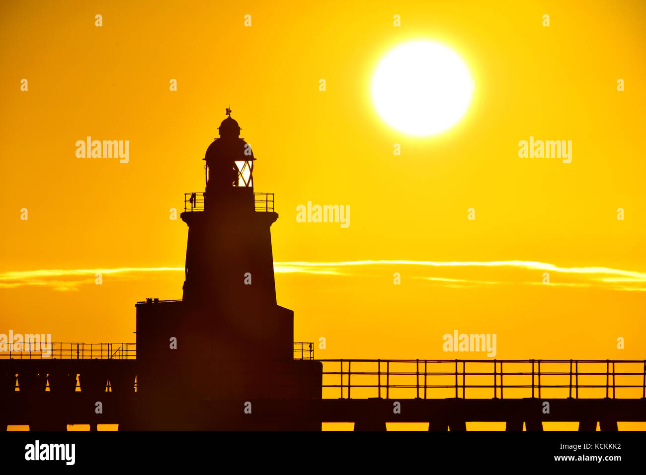 Blyth pier and lighthouse at sunrise with sun directly to the right of ...