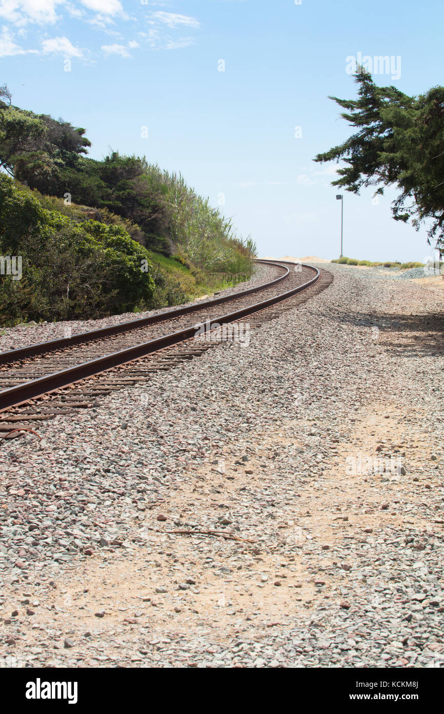 Railroad tracks curing around a bend on a gravel path Stock Photo - Alamy