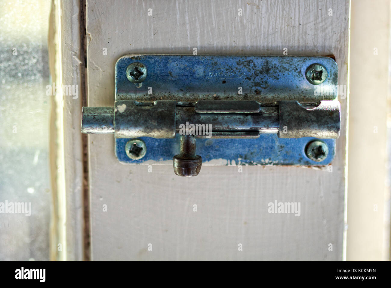 An old-fashioned slide latch lock on a white wooden door Stock Photo ...