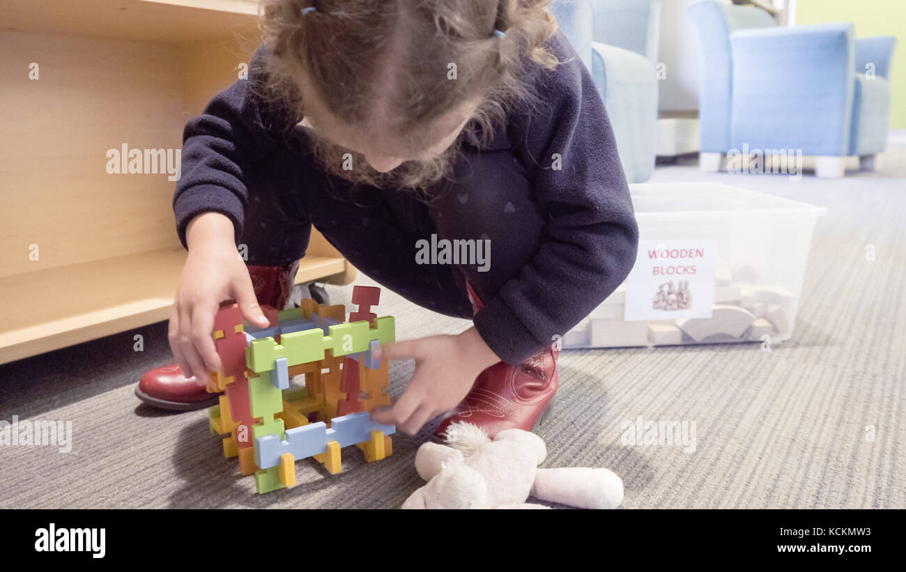 Little girl playing with building blocks on the floor Stock Photo - Alamy