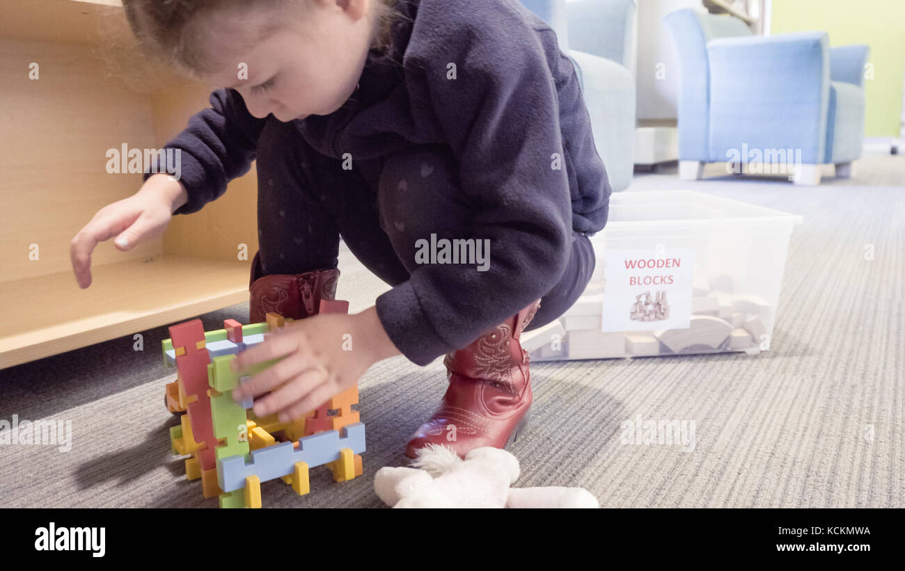 Little girl playing with building blocks on the floor Stock Photo - Alamy