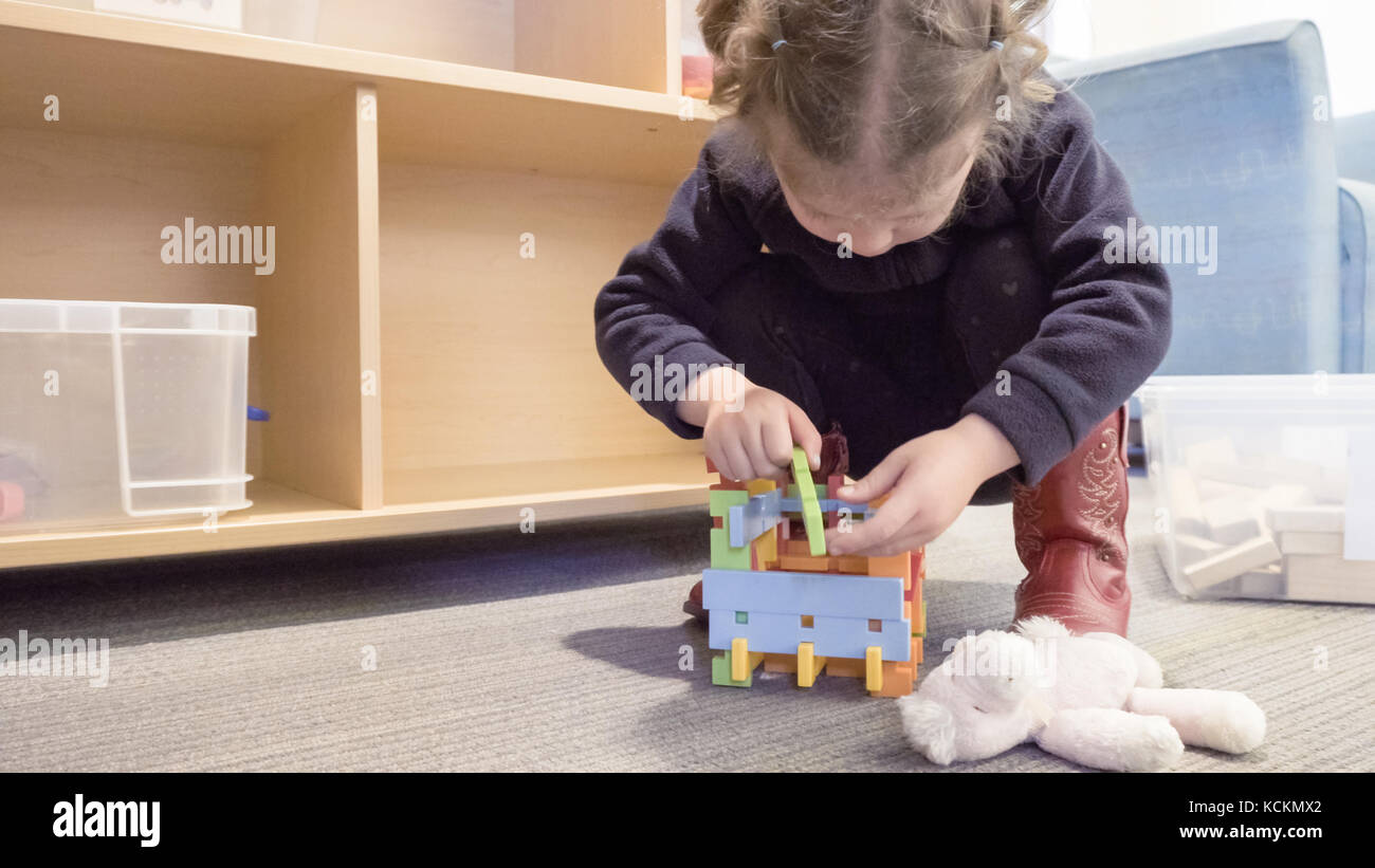 Little girl playing with building blocks on the floor Stock Photo - Alamy