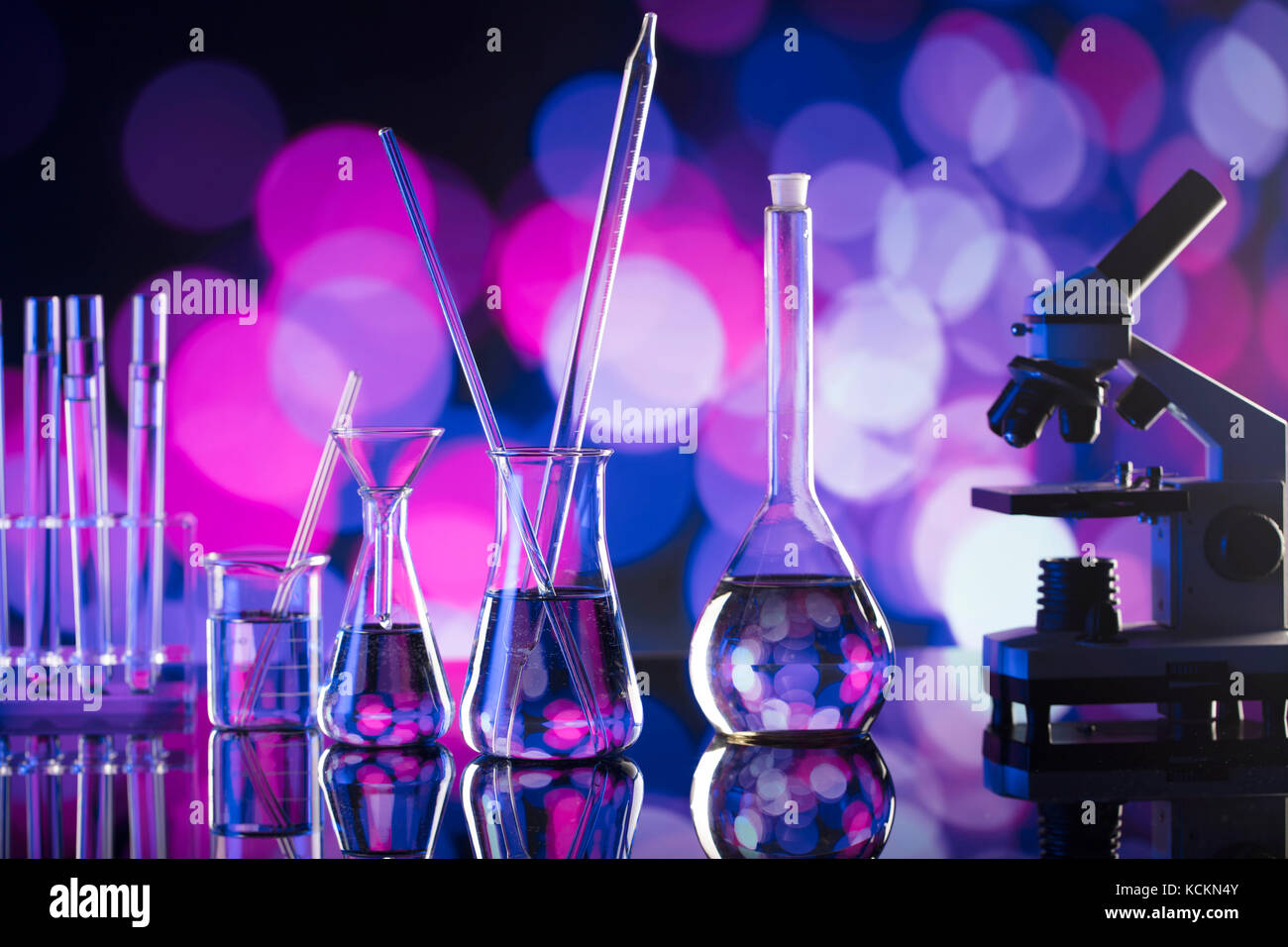 Laboratory concept. Beakers, microscope and test-tubes. Coloful bokeh ...
