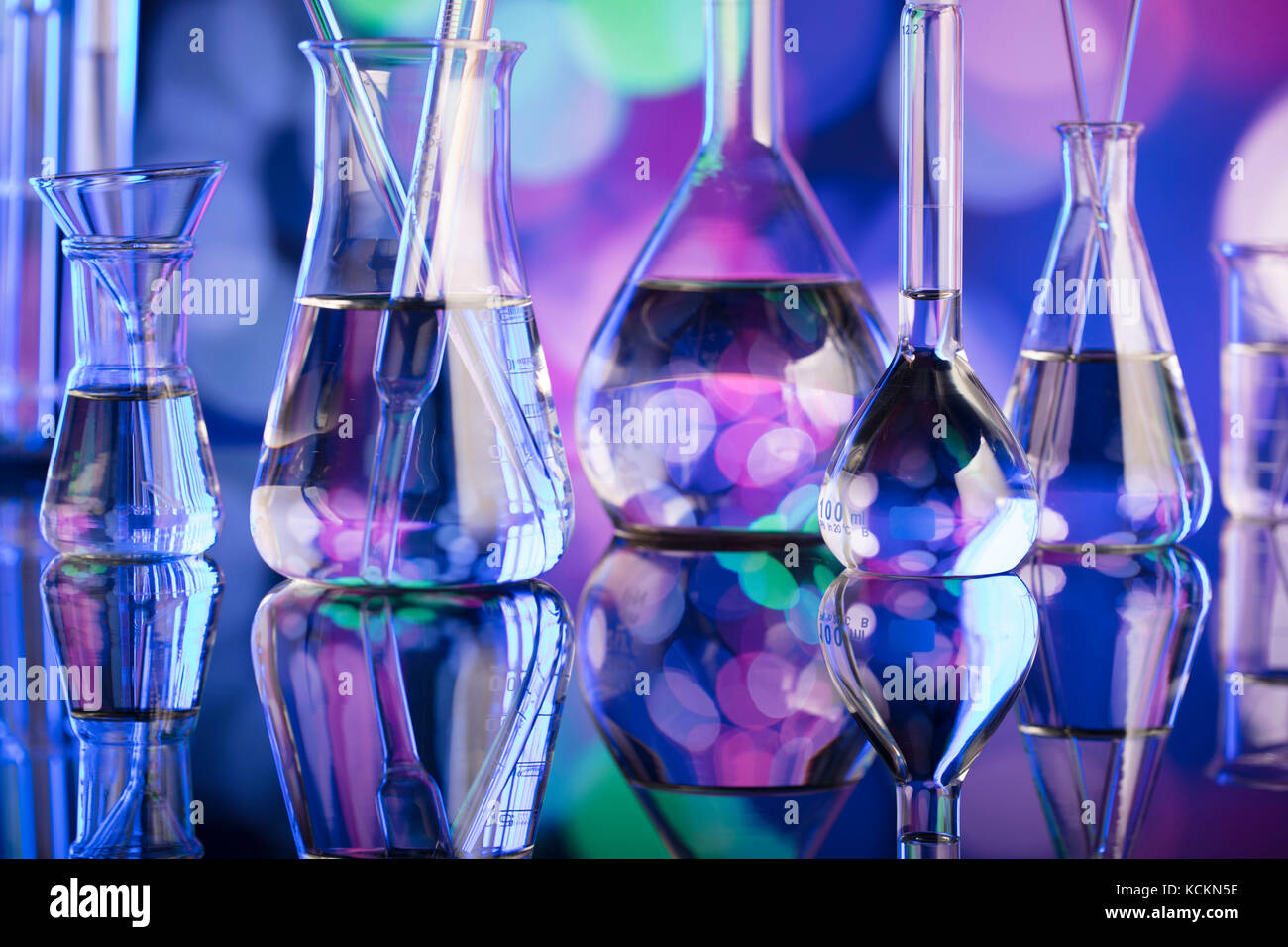 Laboratory concept. Beakers, microscope and test-tubes. Coloful bokeh ...