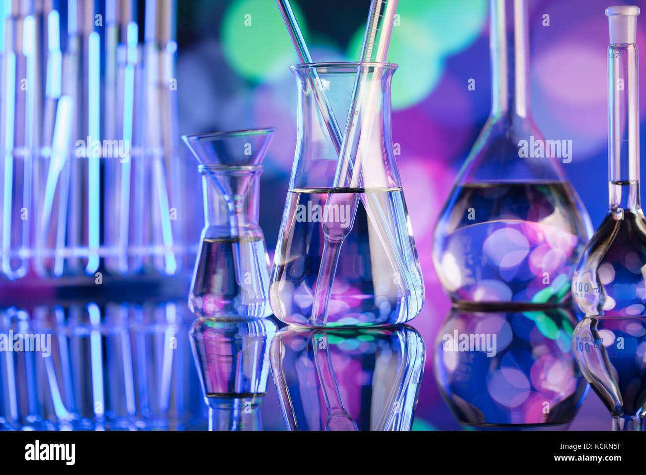 Laboratory concept. Beakers, microscope and test-tubes. Coloful bokeh ...