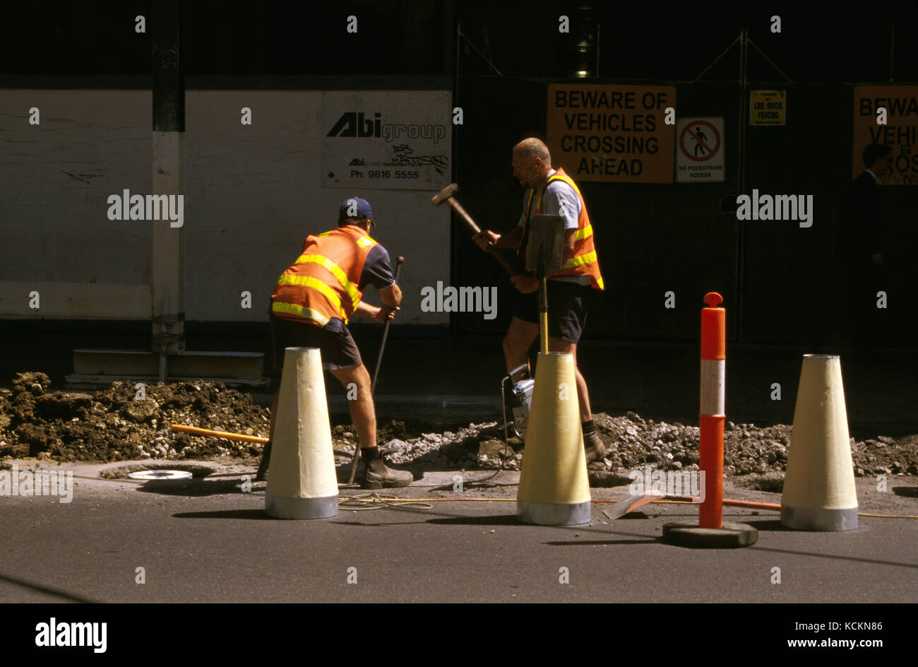 Construction workers, using crowbar and mallet to mend road. Melbourne ...