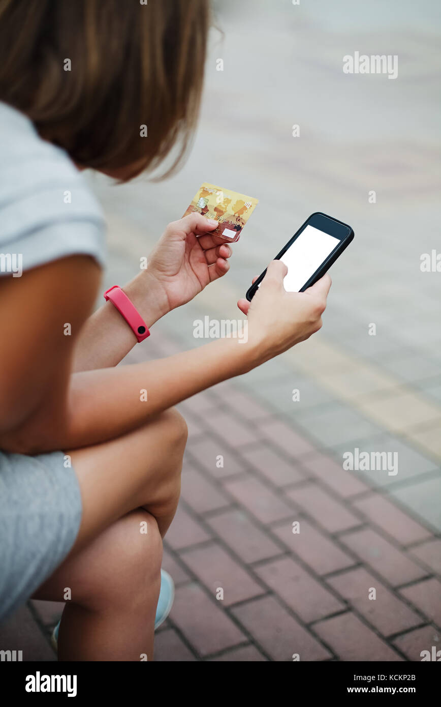 Woman using phone and card for shopping Stock Photo - Alamy