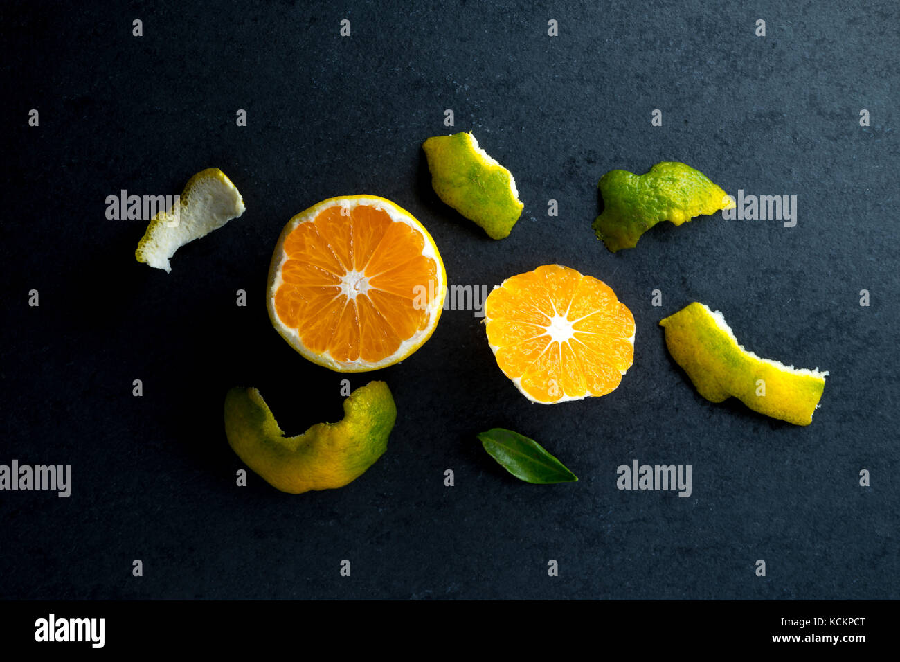 Peeled yellow mandarin and peel on a gray table horizontal Stock Photo ...